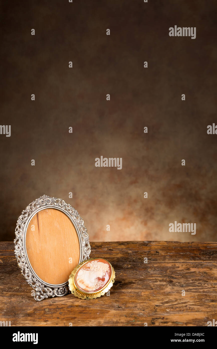 Baroque photo frame and a vintage cameo brooch Stock Photo - Alamy