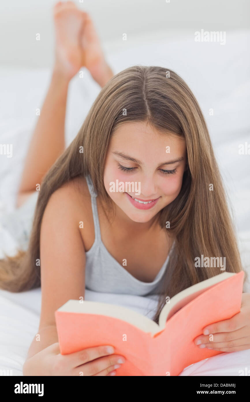 Smiling girl reading a book Stock Photo - Alamy
