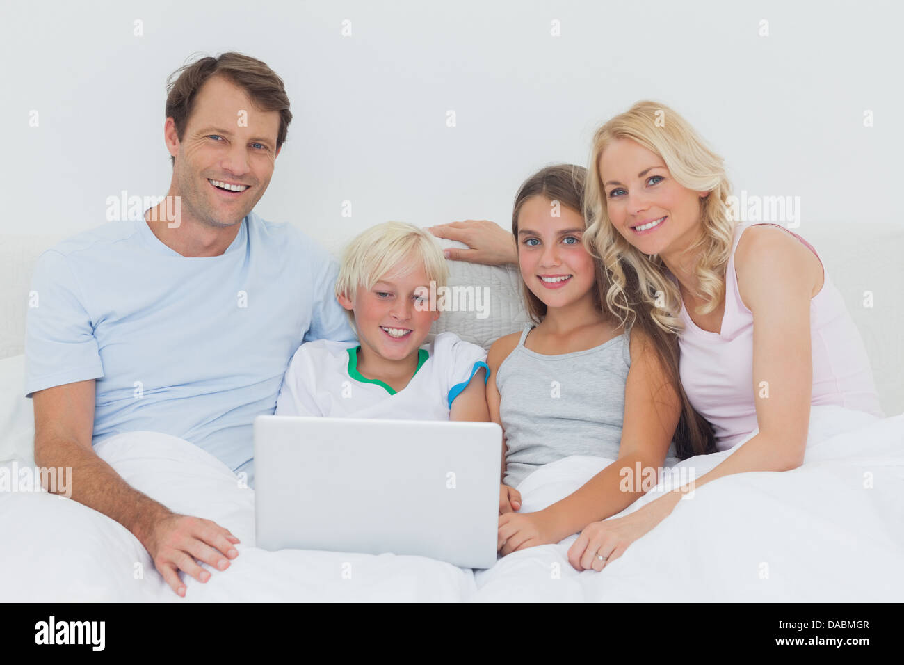 Smiling family using a laptop together Stock Photo - Alamy