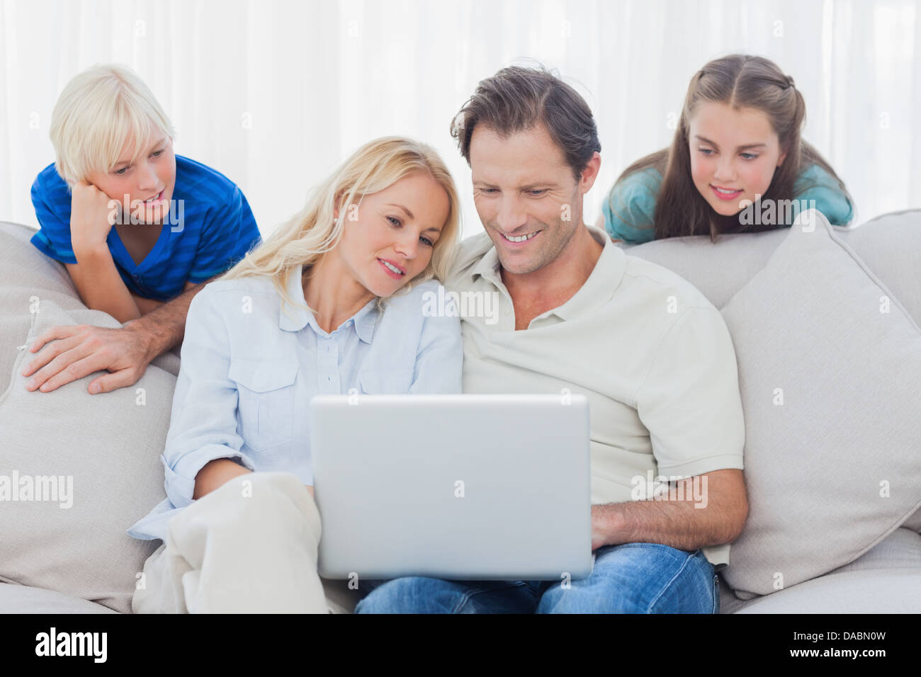 Children looking at parents using a laptop Stock Photo - Alamy