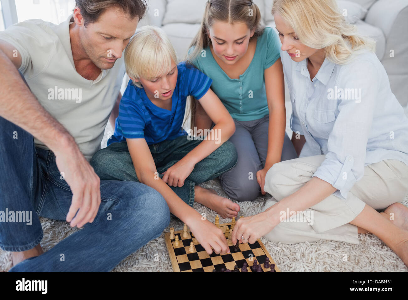 Portrait of a cute family playing chess Stock Photo - Alamy