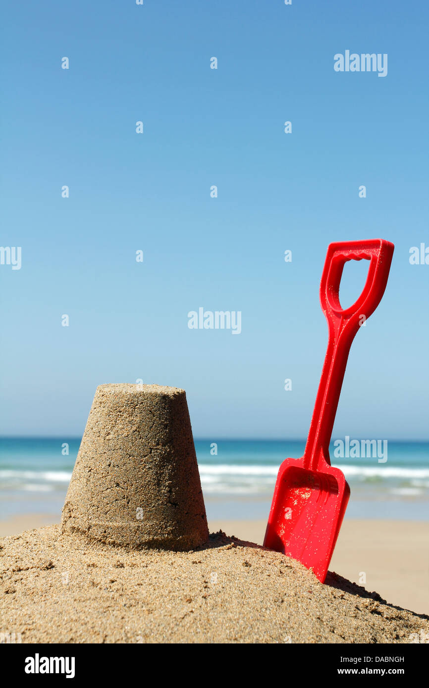 Sandcastle on beach with spade Stock Photo - Alamy