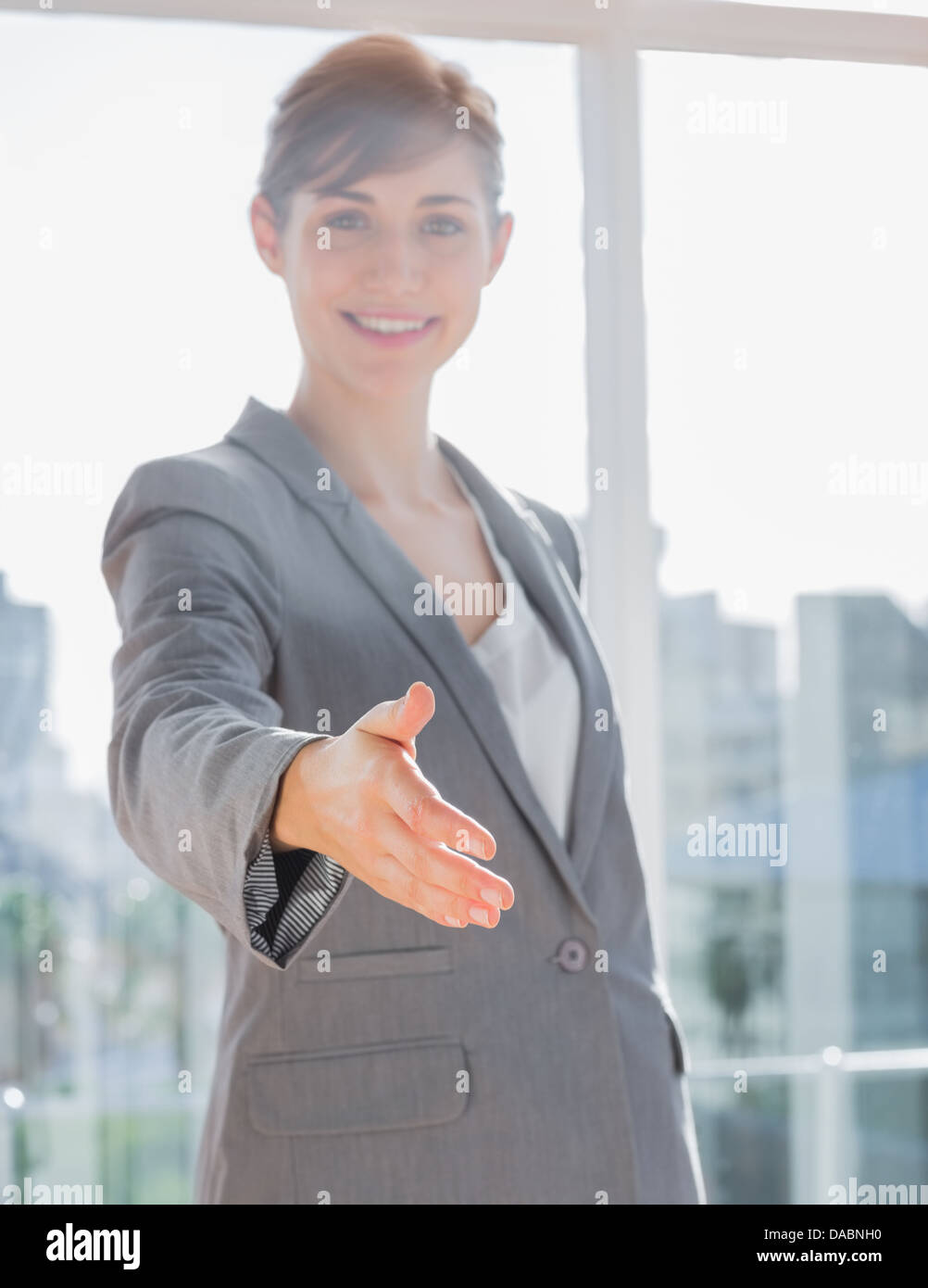 Businesswoman smiling with hand out Stock Photo - Alamy