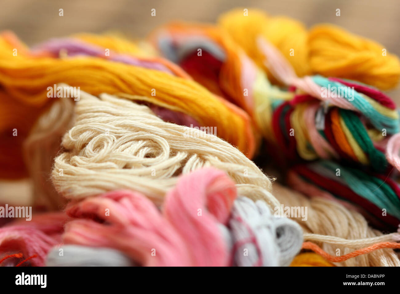 a tangle of colored threads for embroidery and needle Stock Photo - Alamy