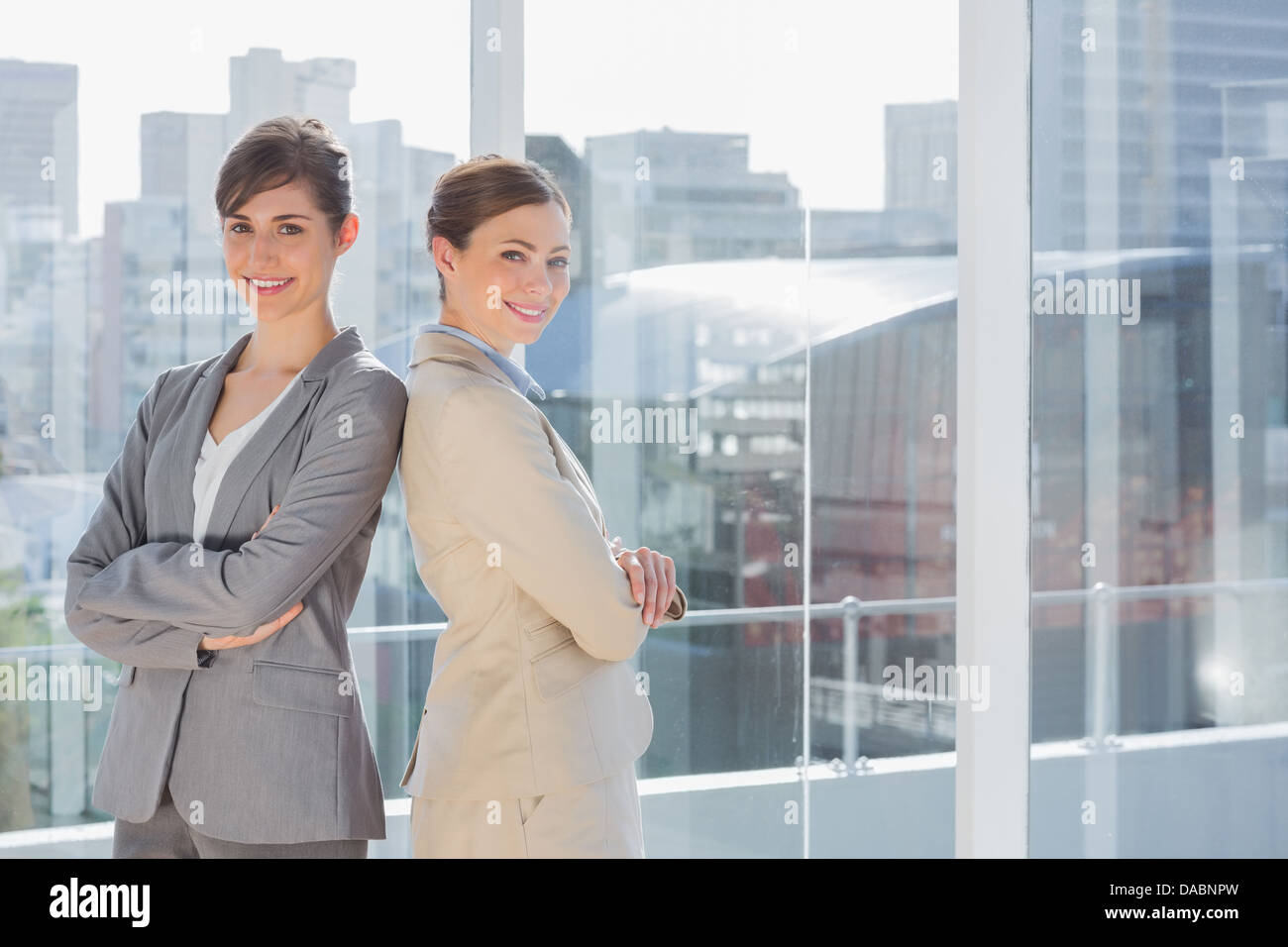 Businesswomen standing back to back Stock Photo - Alamy