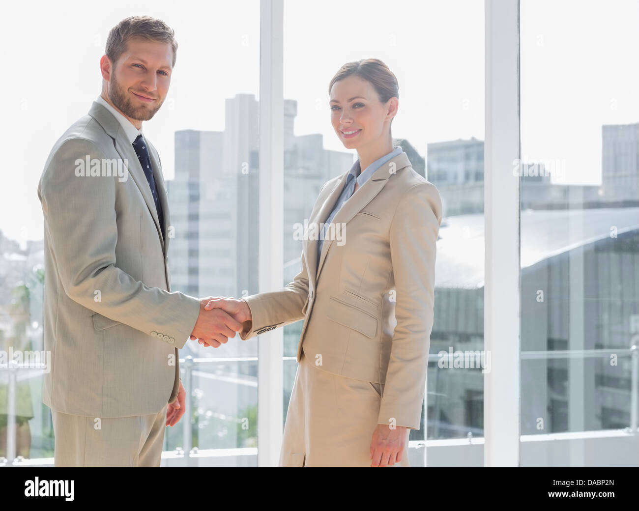 Business people shaking hands and smiling at camera Stock Photo - Alamy