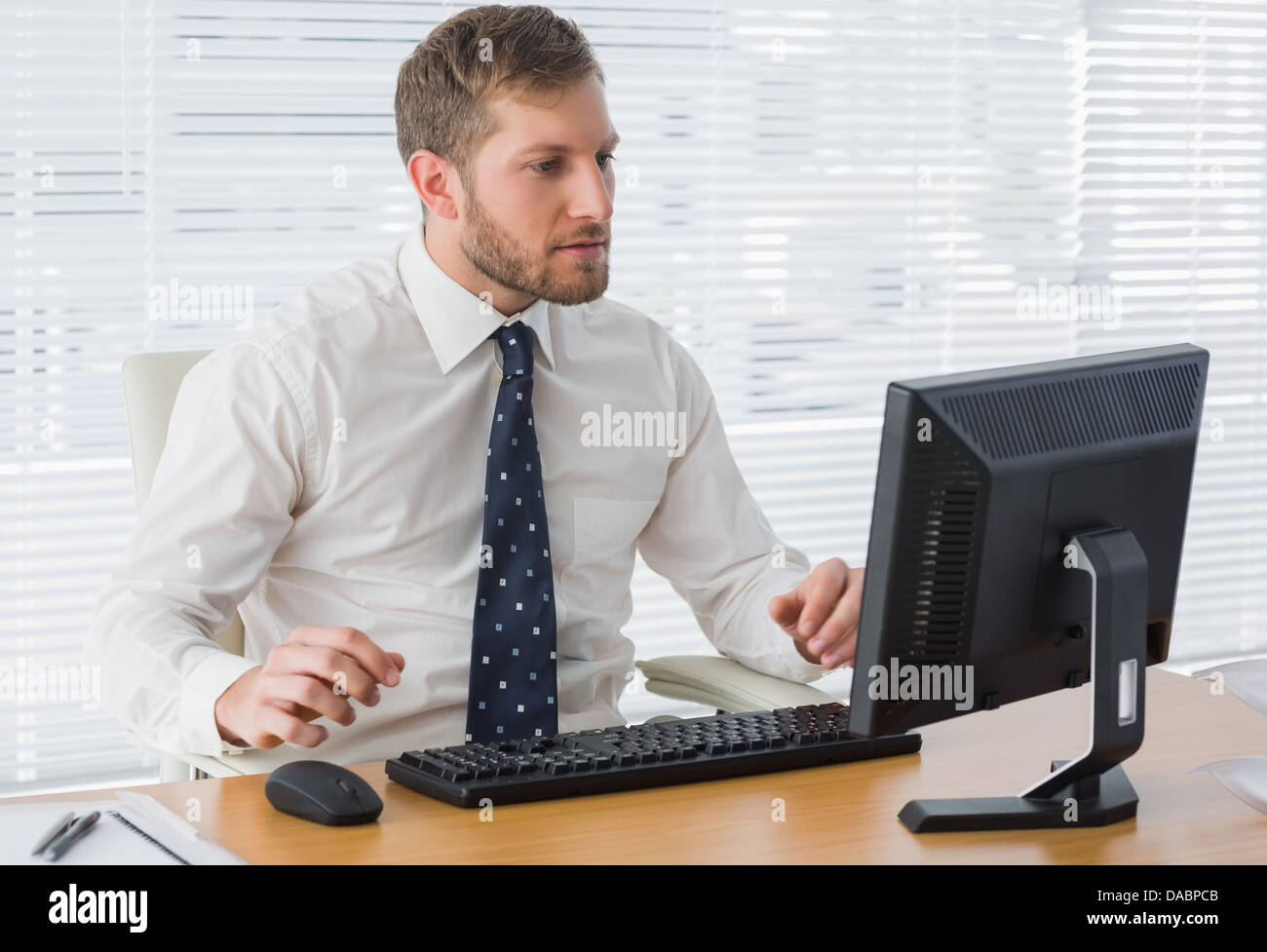 Serious businessman looking at computer Stock Photo - Alamy