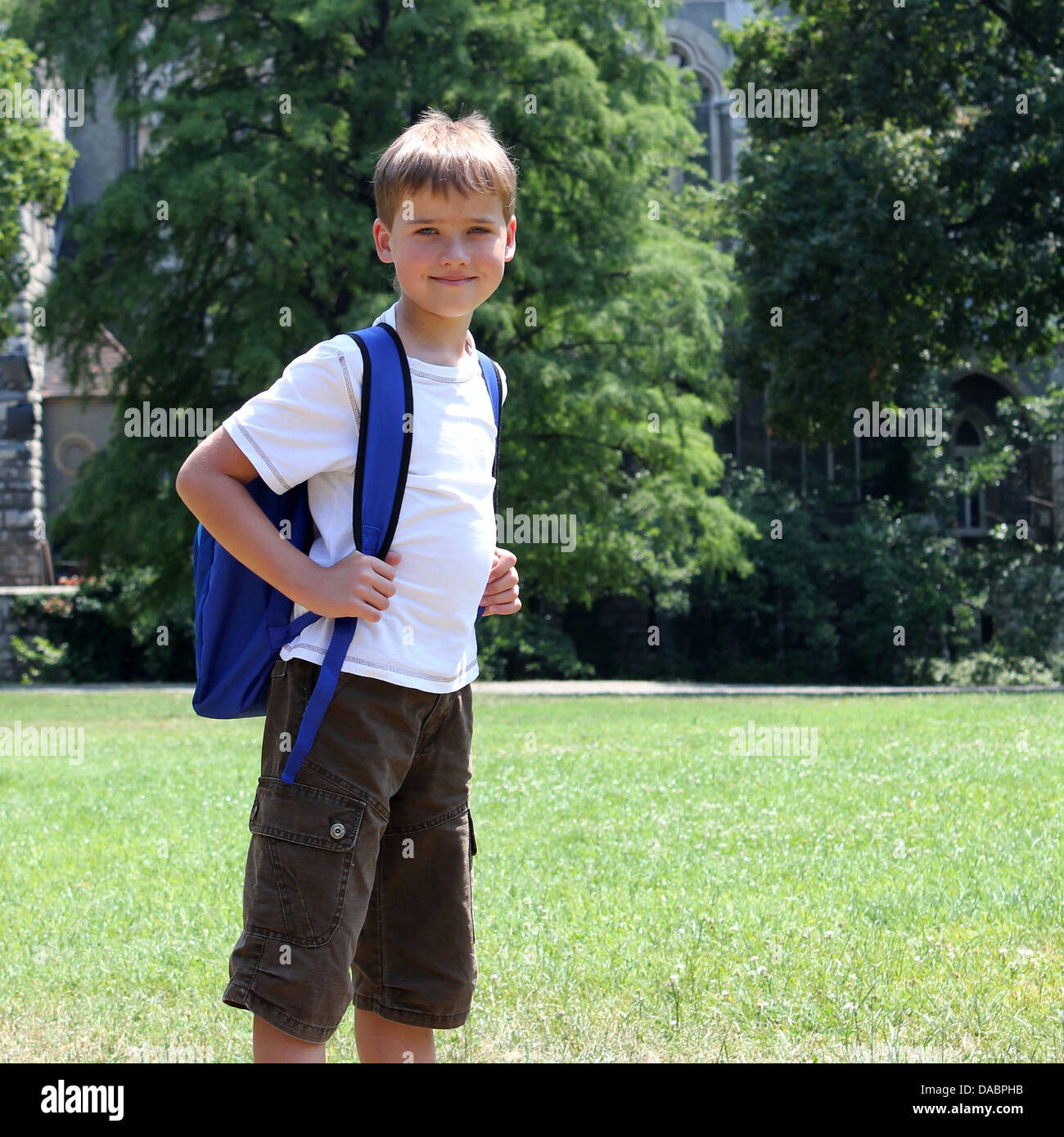 closeup shot of a happy young boy carrying a backpack standing in a ...