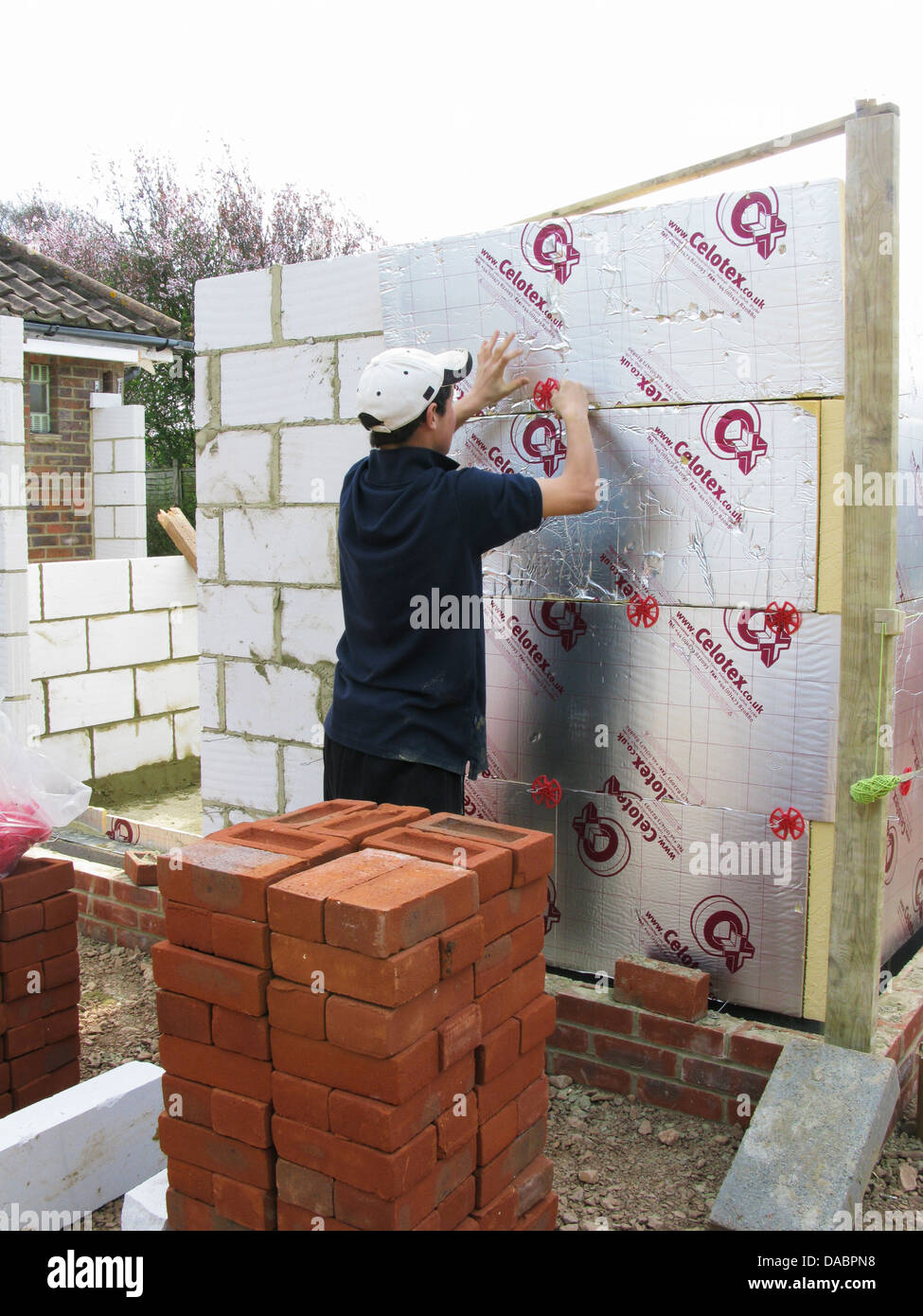 Apprentice builder putting a universal insulation retaining disc ...