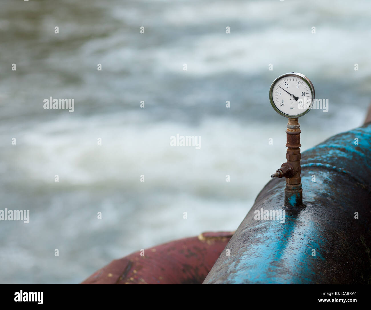 Barometer on a blue rusty water pipe above a river in the city Stock ...