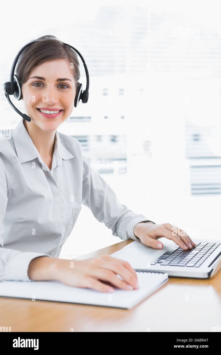 Pretty call centre agent working at desk Stock Photo - Alamy