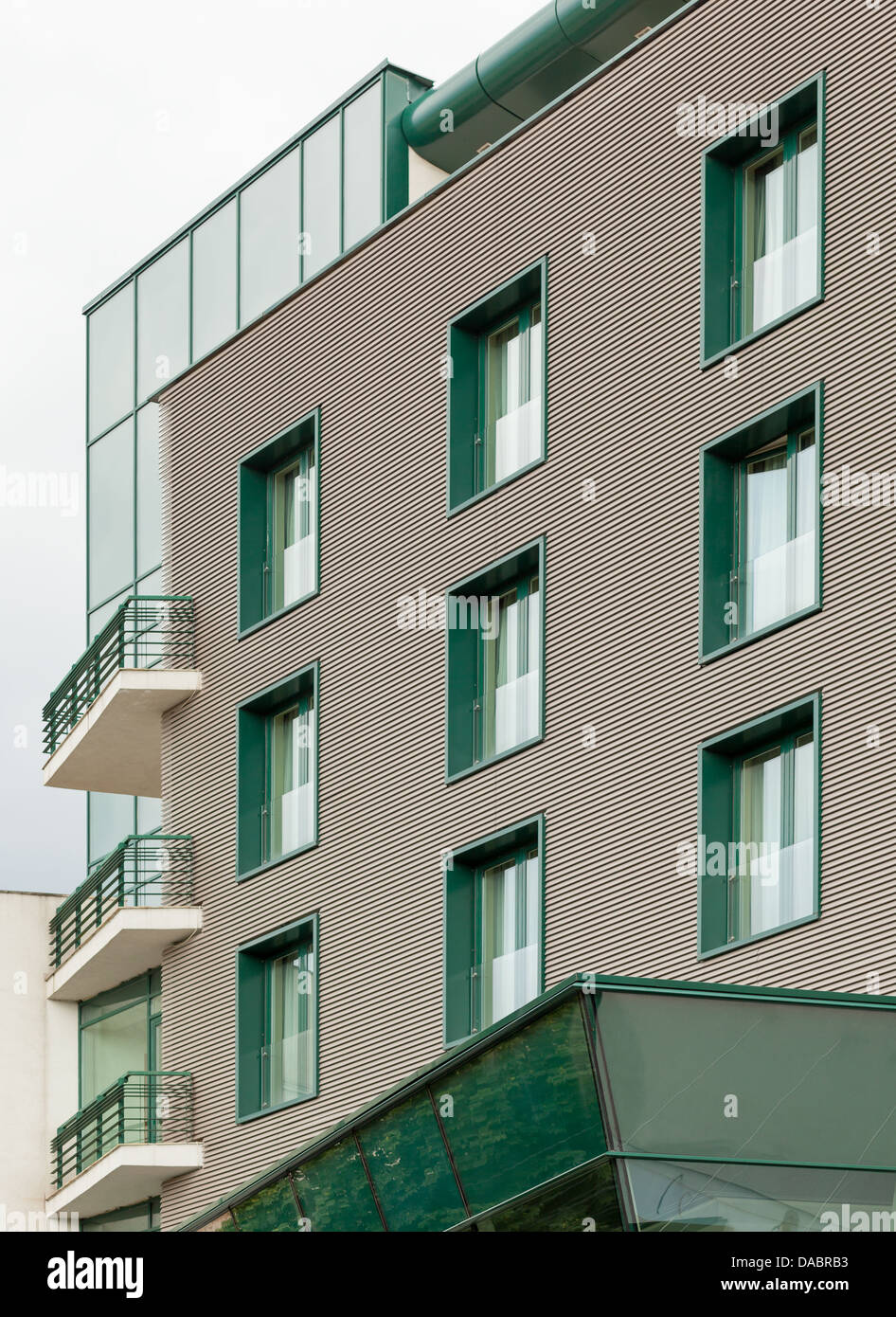 Top of an office building with green windows and metal stripes on the ...