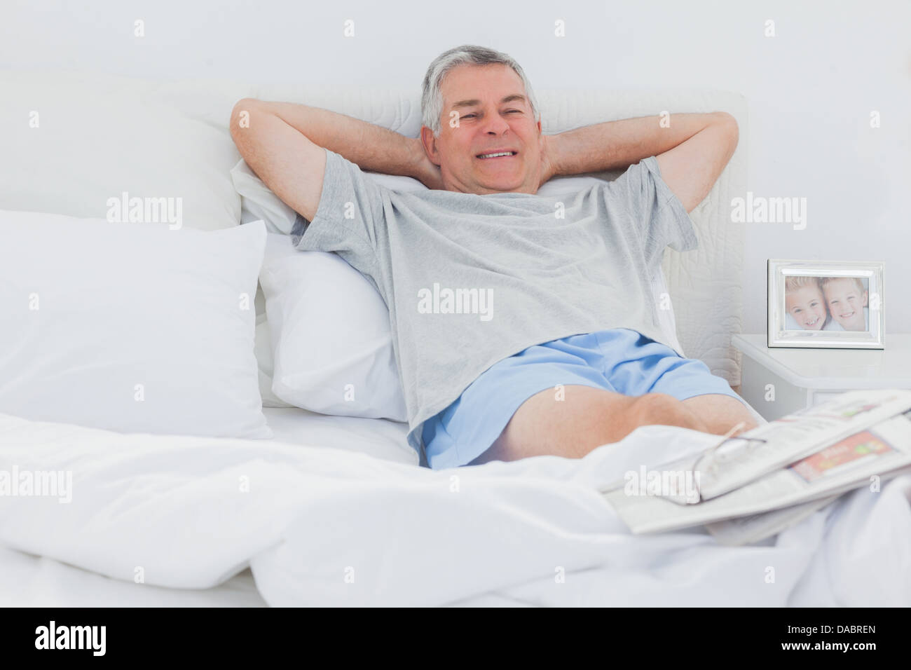 Retired man relaxing in bed Stock Photo - Alamy
