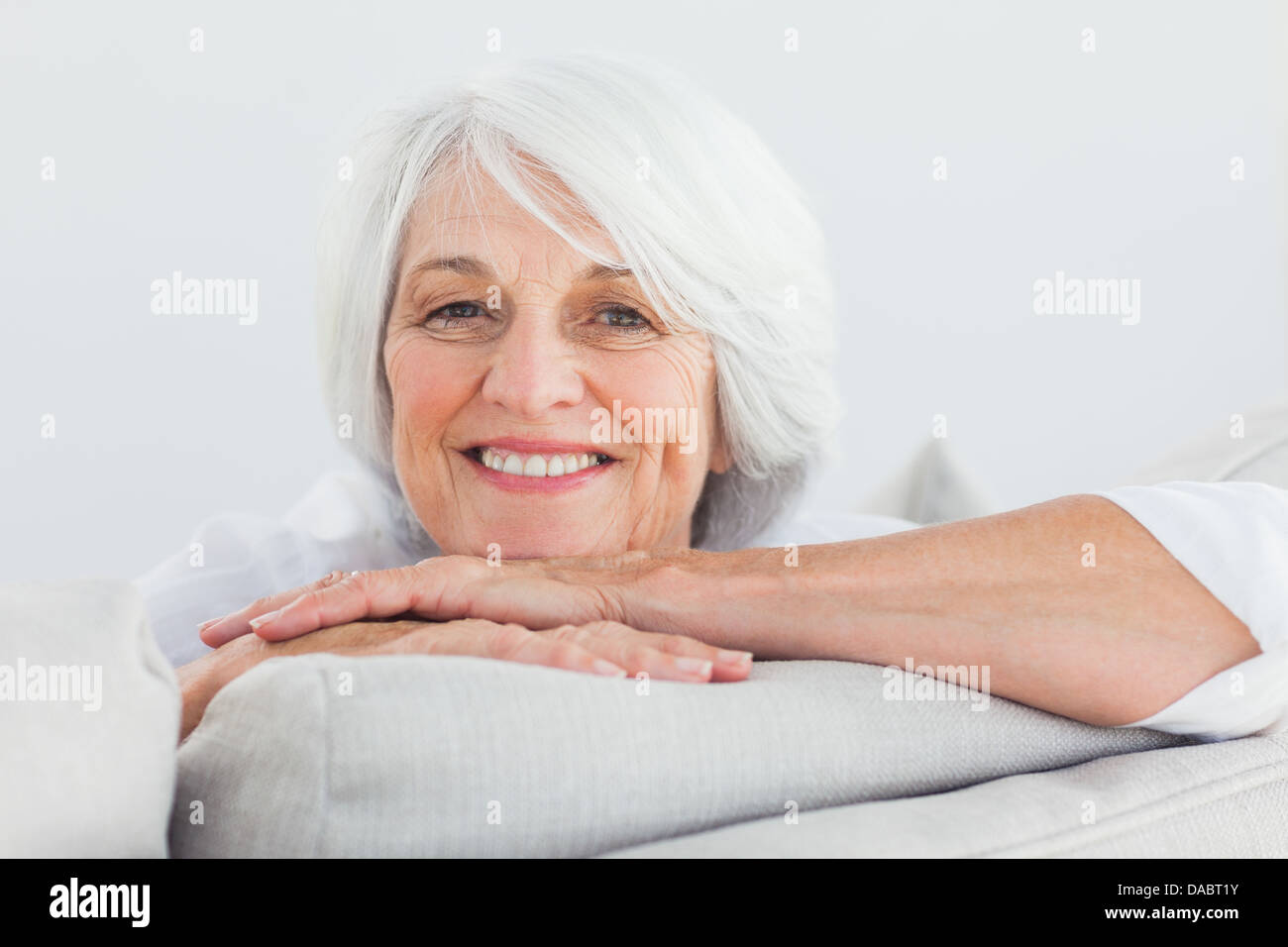 Woman leaning on a couch Stock Photo - Alamy