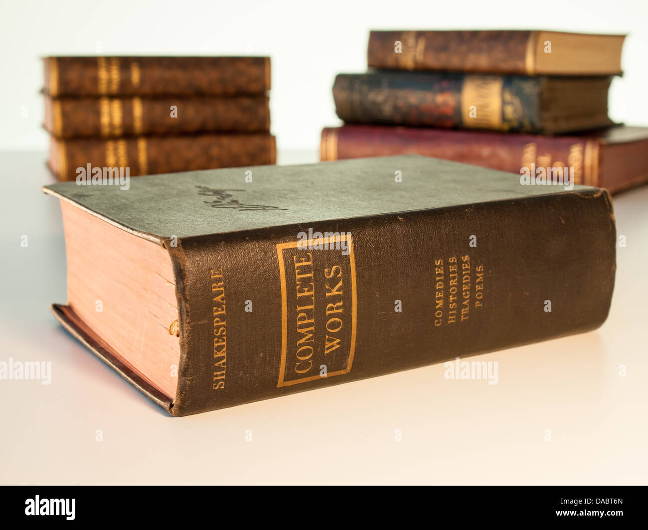 an old copy of the complete works of shakespeare with stacks of old ...