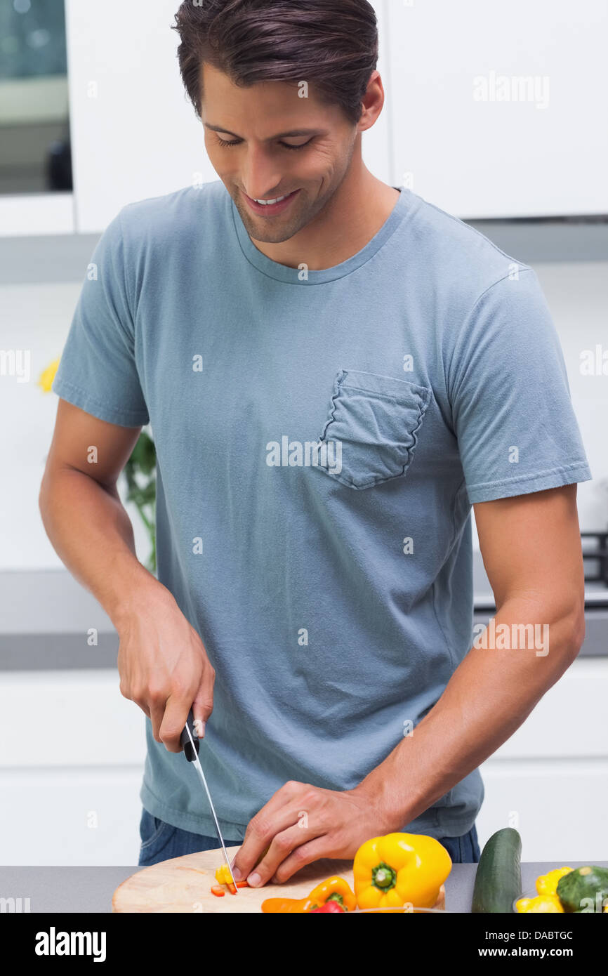 Attractive man cutting vegetables Stock Photo - Alamy