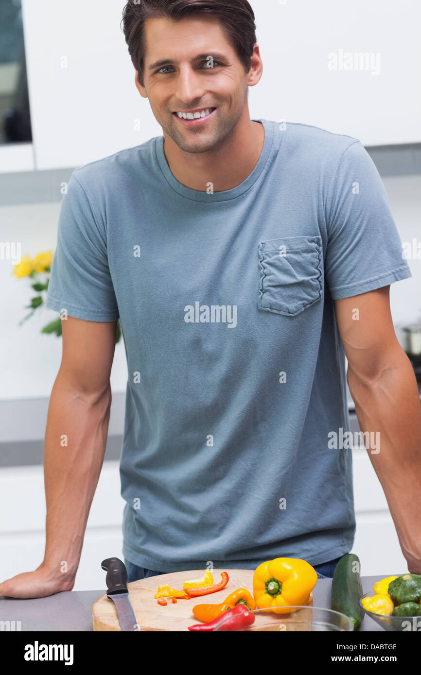 Handsome man leaning on the counter of his kitchen Stock Photo - Alamy