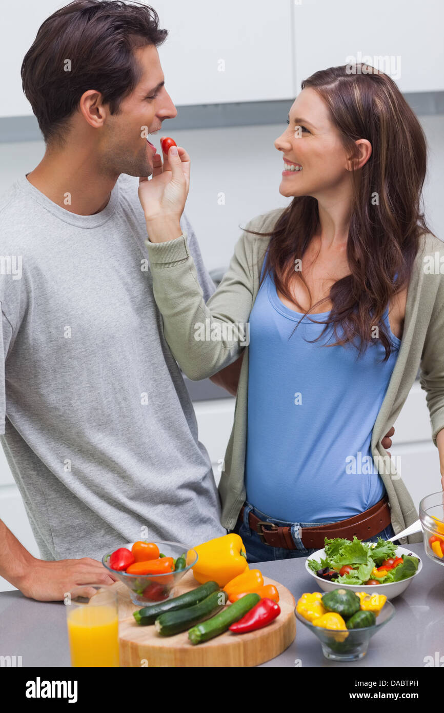 Attractive woman feeding her husband cherry tomato Stock Photo - Alamy