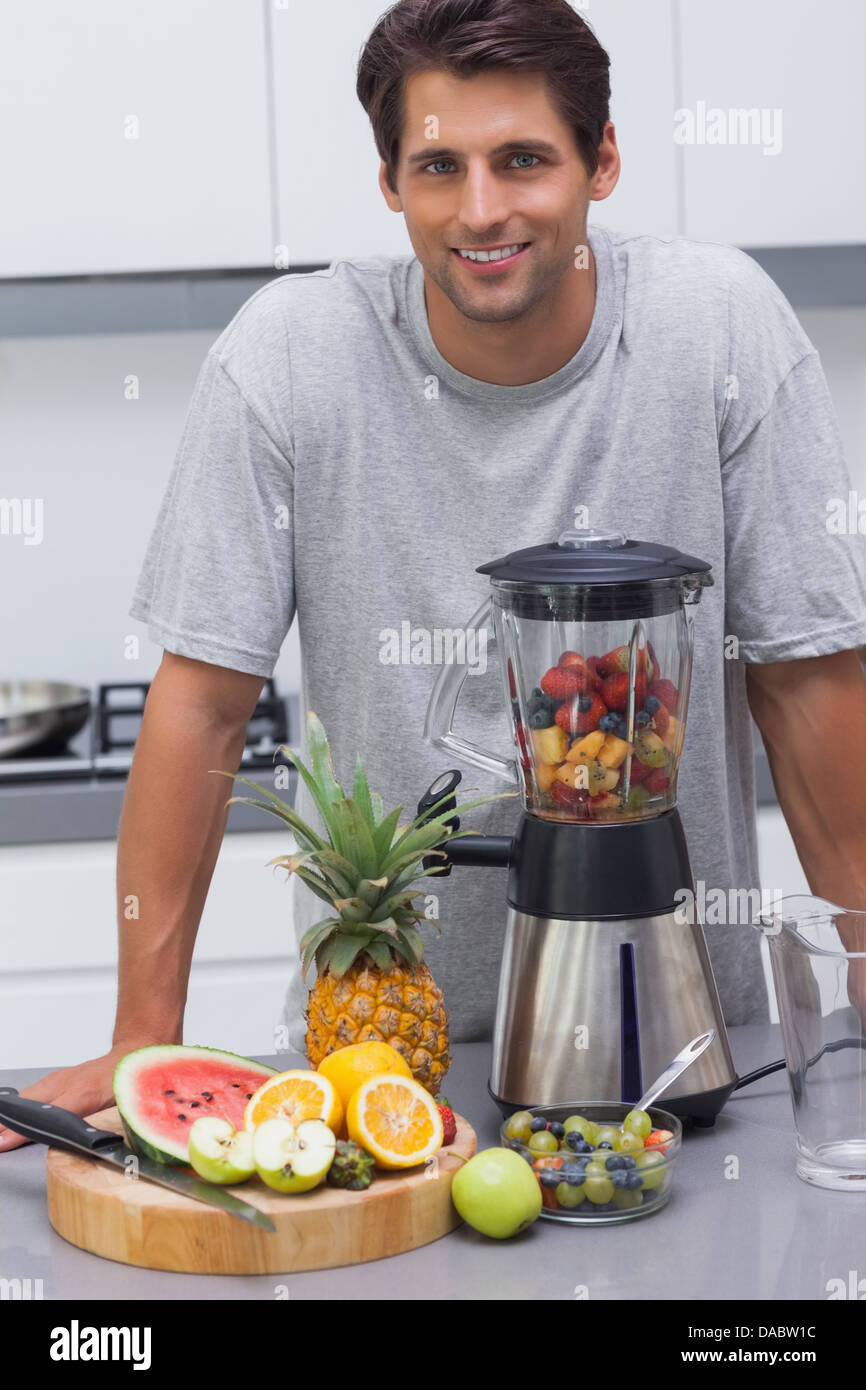 Handsome man leaning on the counter of his kitchen Stock Photo - Alamy