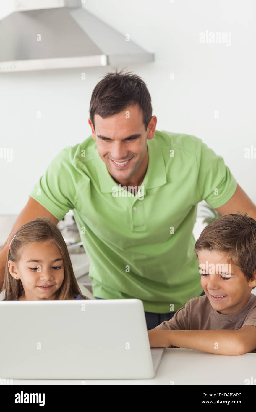 Man and his children using a laptop together Stock Photo - Alamy