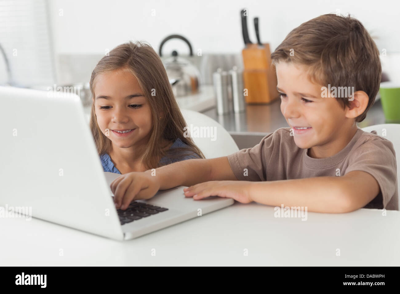 Siblings using a laptop together Stock Photo - Alamy