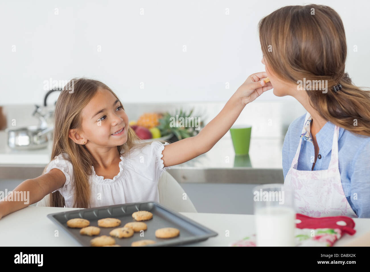 Young girl giving a cookie to her mother Stock Photo - Alamy