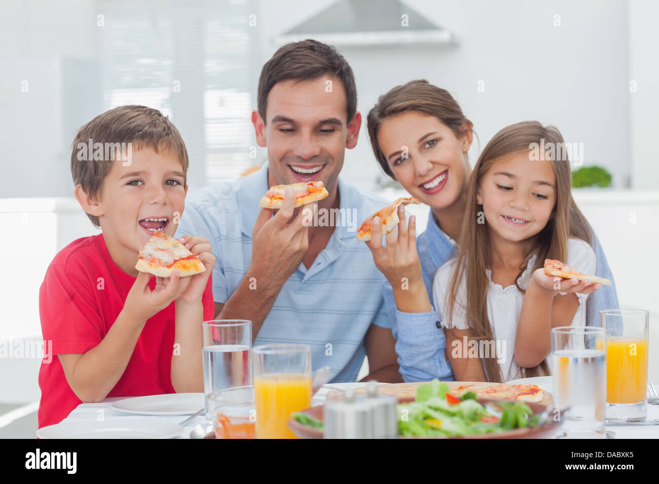 Family eating pizza slices Stock Photo - Alamy
