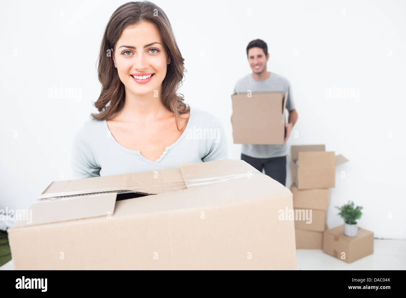 Pretty woman holding boxes in her new house Stock Photo - Alamy