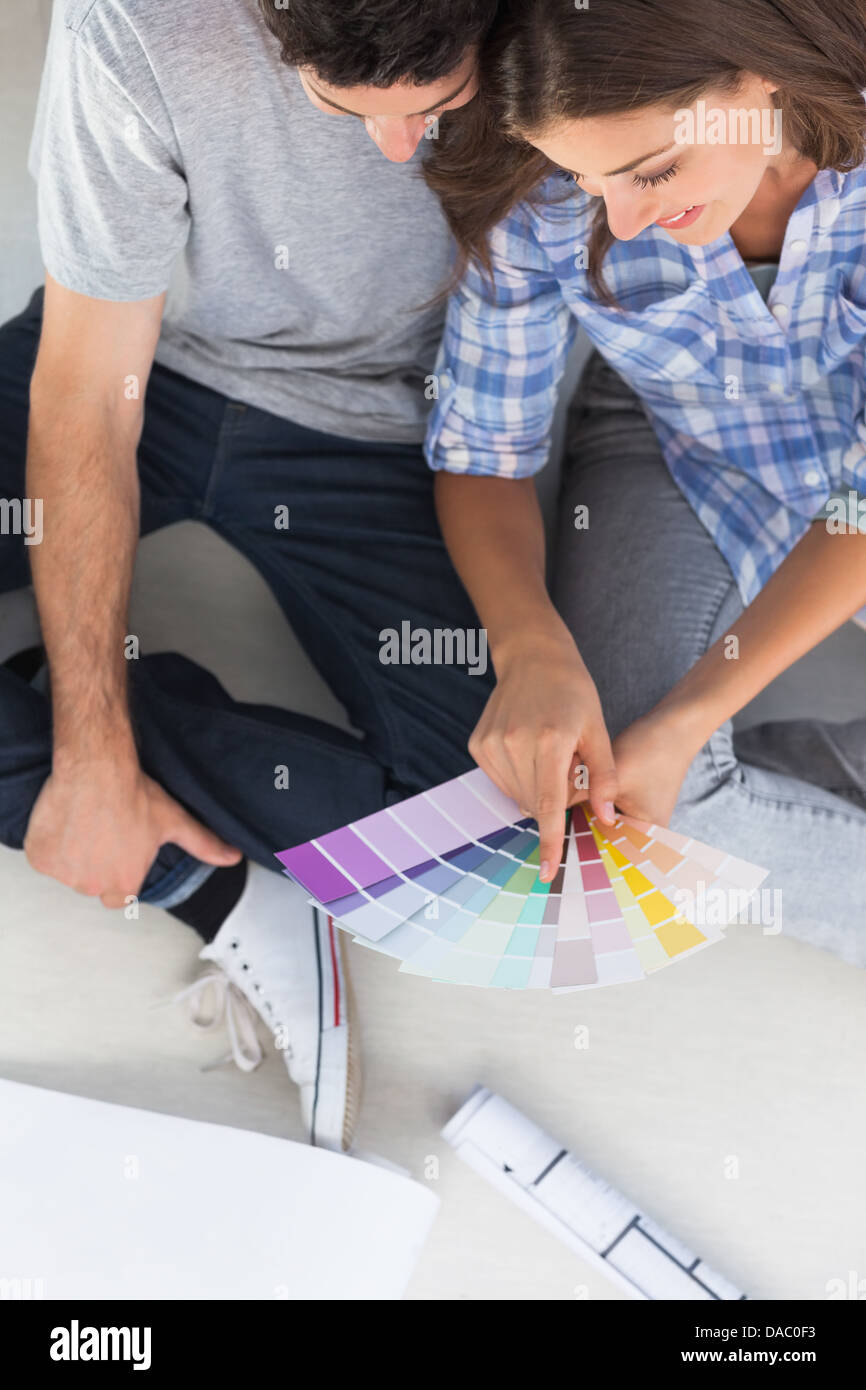 Woman pointing at color charts sitting in her new house Stock Photo - Alamy