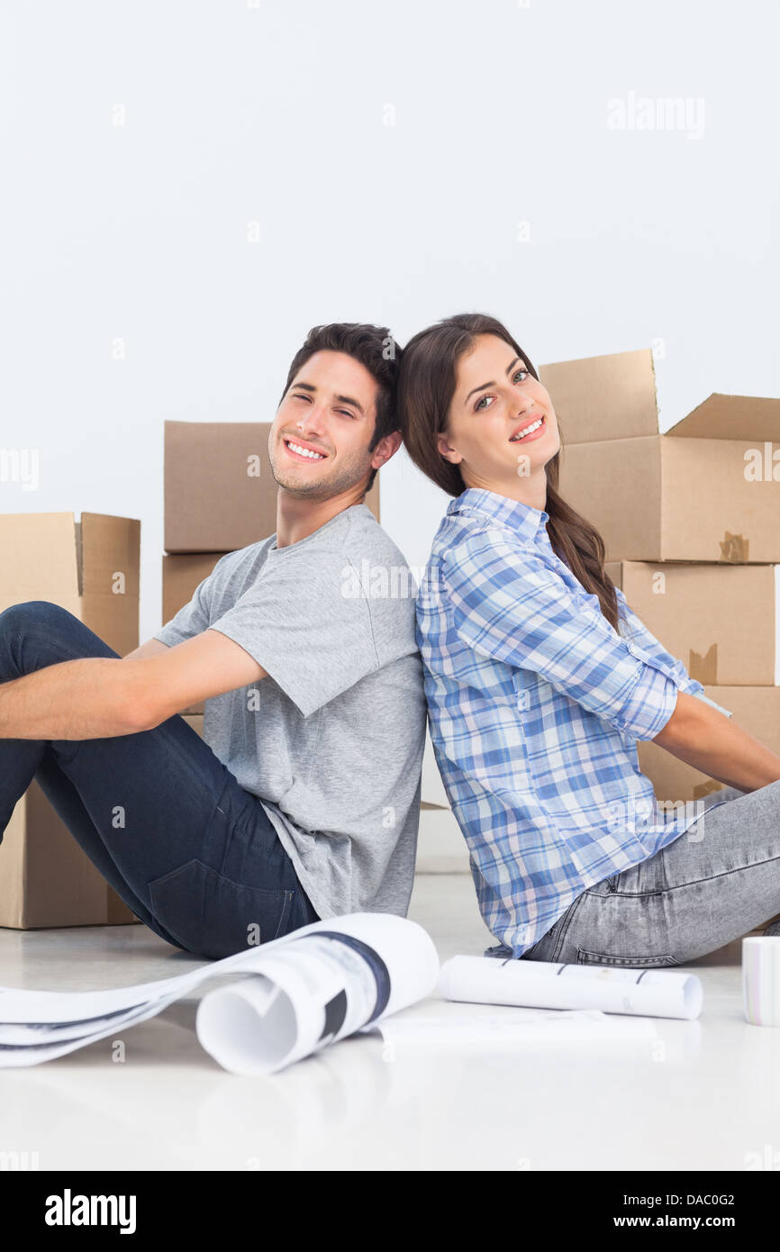 Happy couple sitting back to back Stock Photo - Alamy
