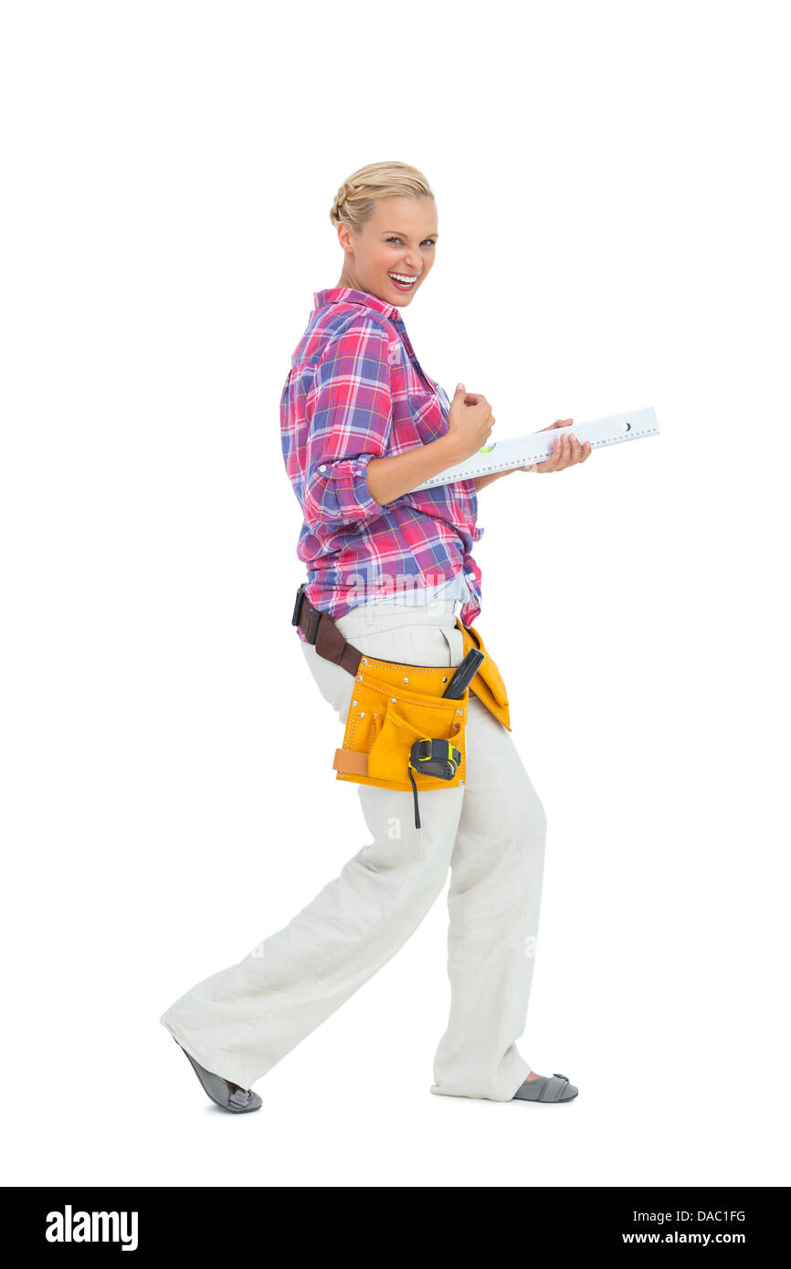 Blonde woman standing while playing with a spirit level Stock Photo - Alamy