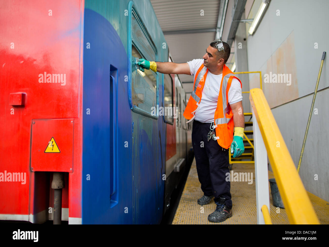 An employee of the German railways cleans a car of a train in the first ...