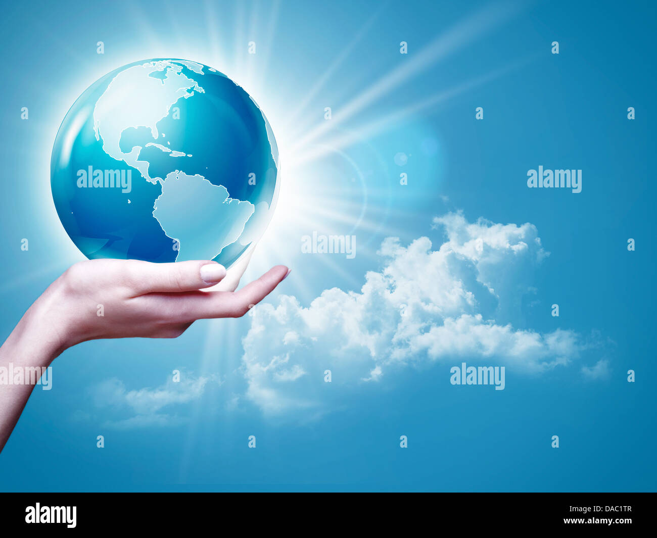 Female arm holding Earth globe against blue skies, environmental ...
