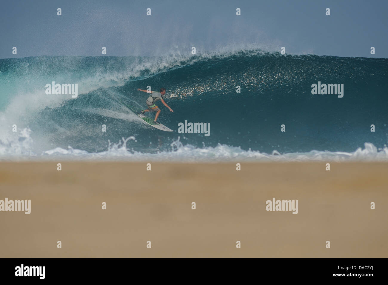 A surfer rides under the falling lip of a wave in Turtles, West Java ...