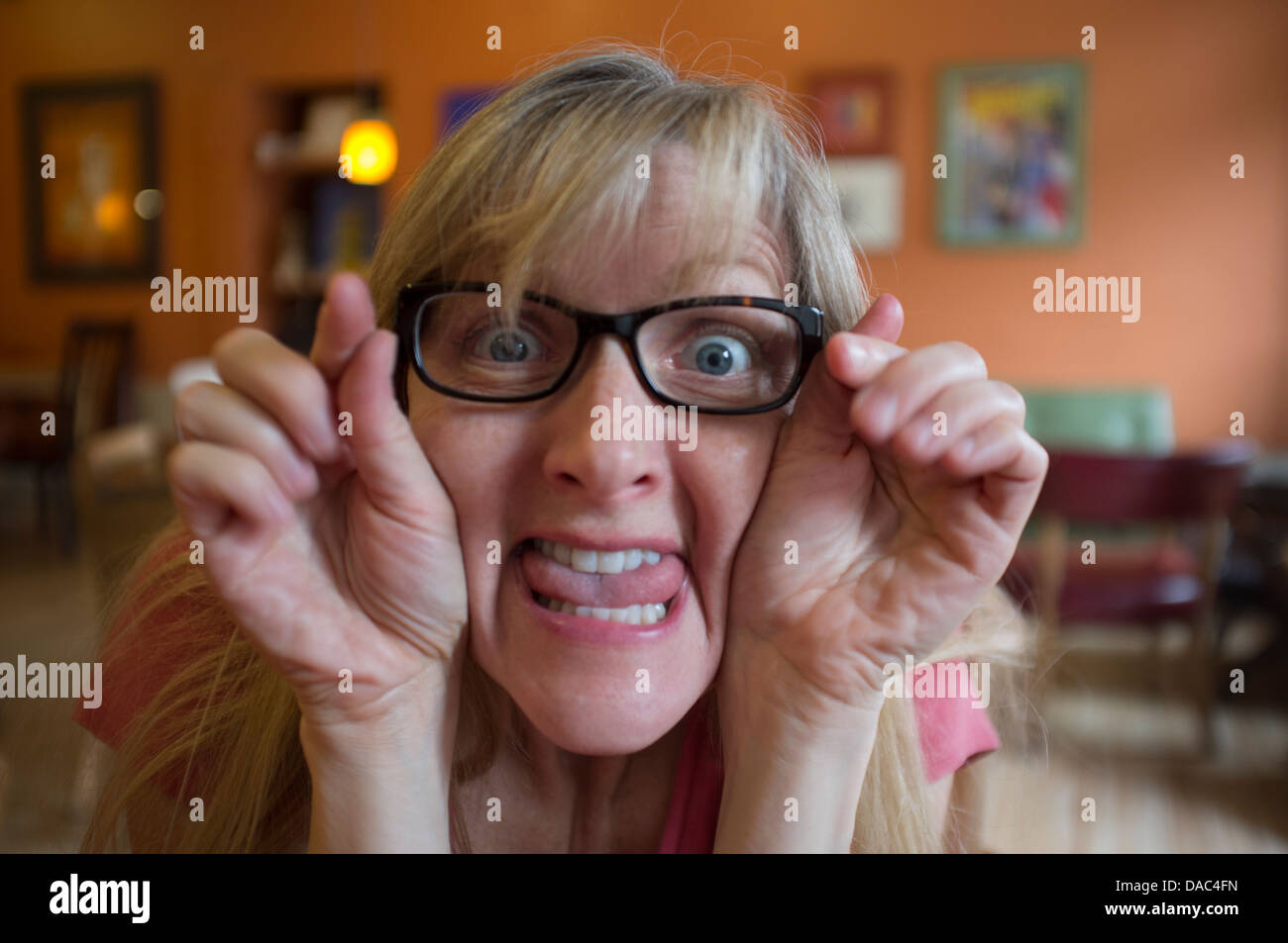 Closeup of woman looking at camera with silly expression- holding hands ...
