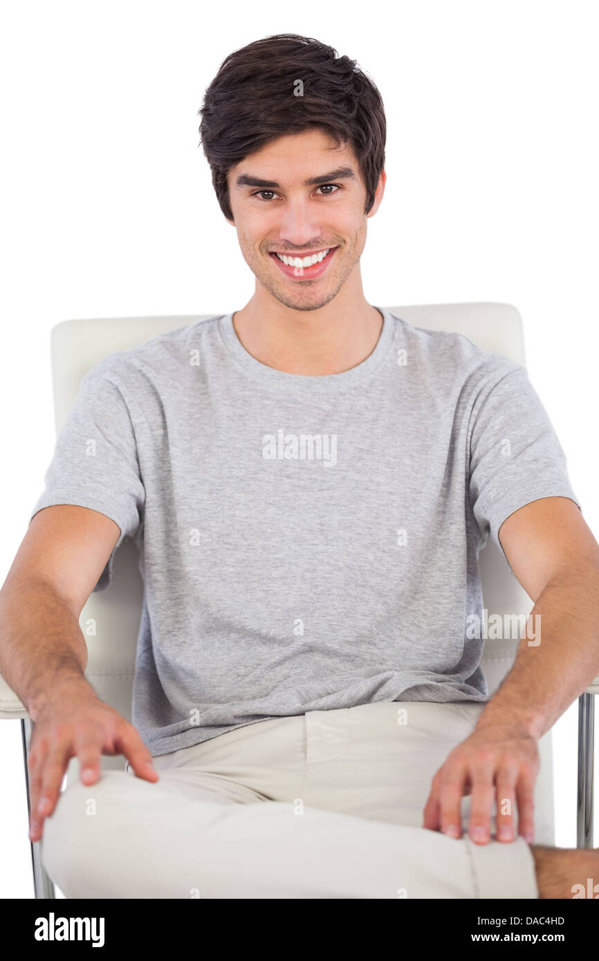 Smiing man sitting on a office chair Stock Photo - Alamy