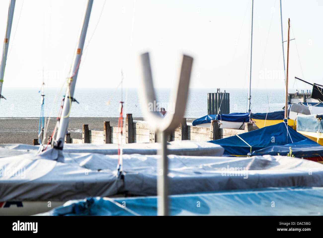 Post in foreground with man's head in between post, Whitstable Stock ...