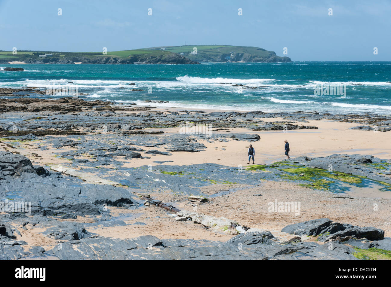 Two people on the quiet beach at Trevone Bay Cornwall UK at low tide ...