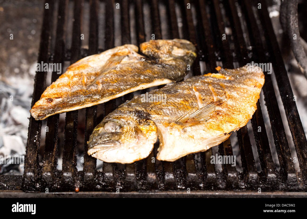 cooking fish on the grill in the restaurant Stock Photo - Alamy