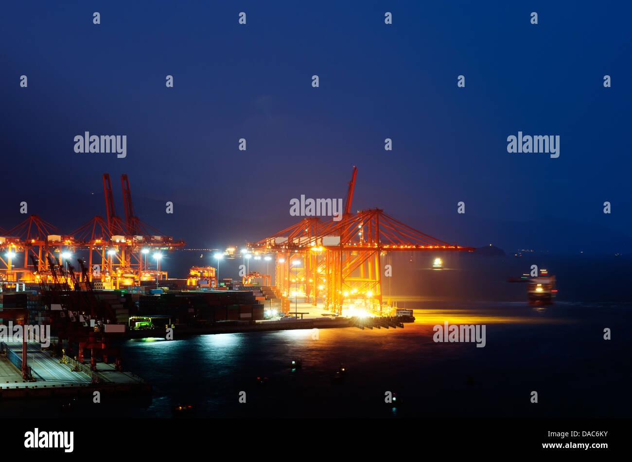 Port warehouse with cargoes and containers at night Stock Photo - Alamy