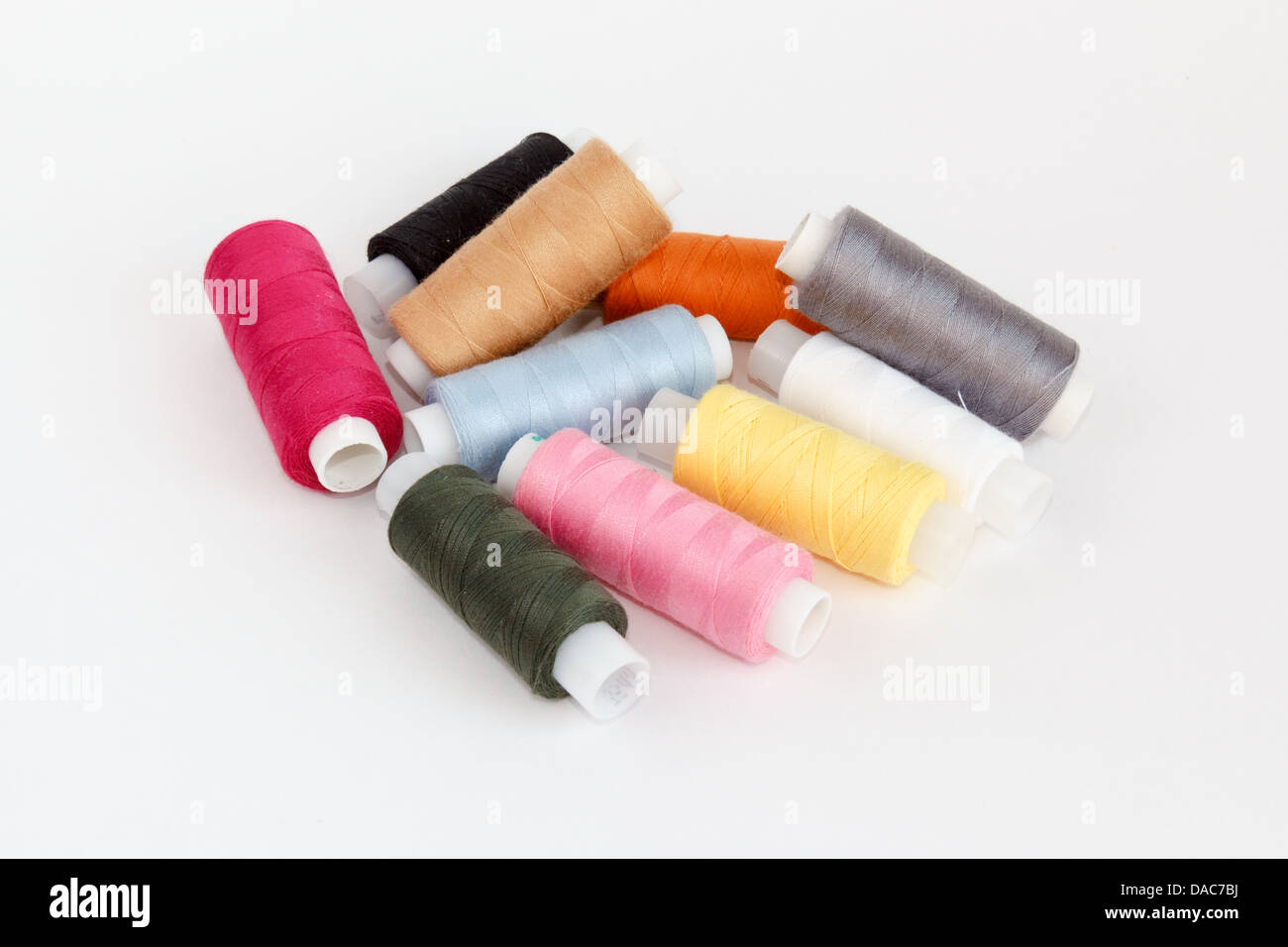Multy coloured bobbins of thread on white background Stock Photo - Alamy