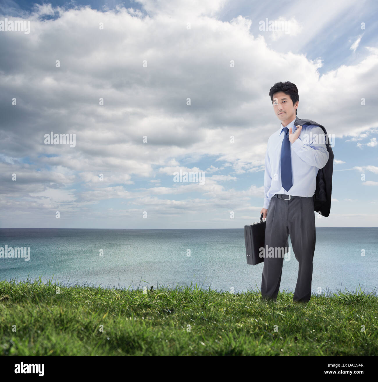 Elegant businessman holding briefcase and his jacket over his shoulder ...