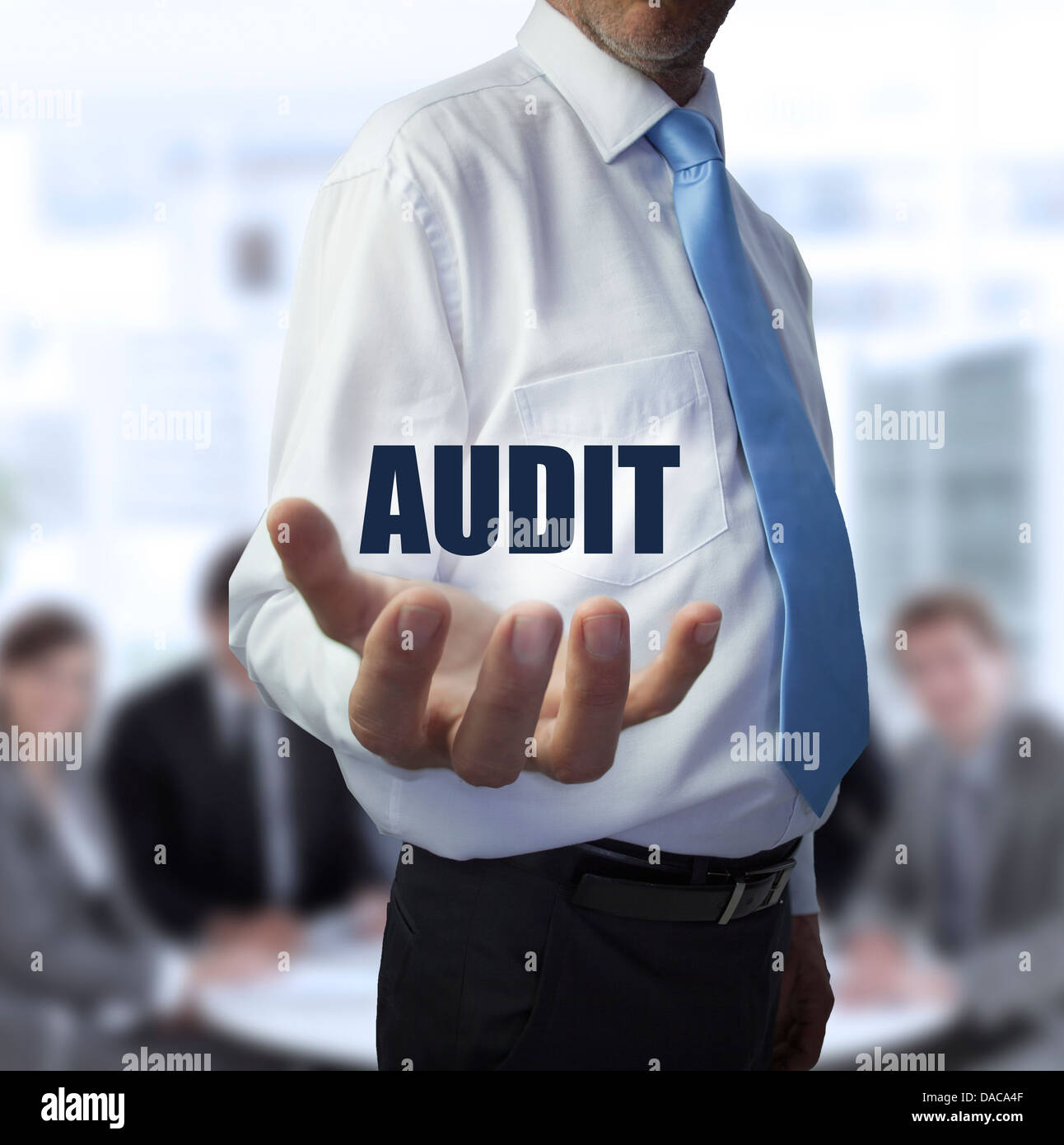 Elegant businessman holding the word audit Stock Photo - Alamy