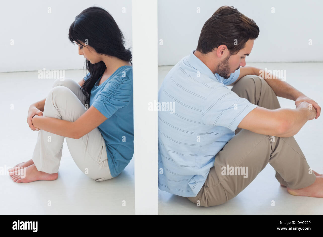 Sitting couple are separated by white wall Stock Photo - Alamy