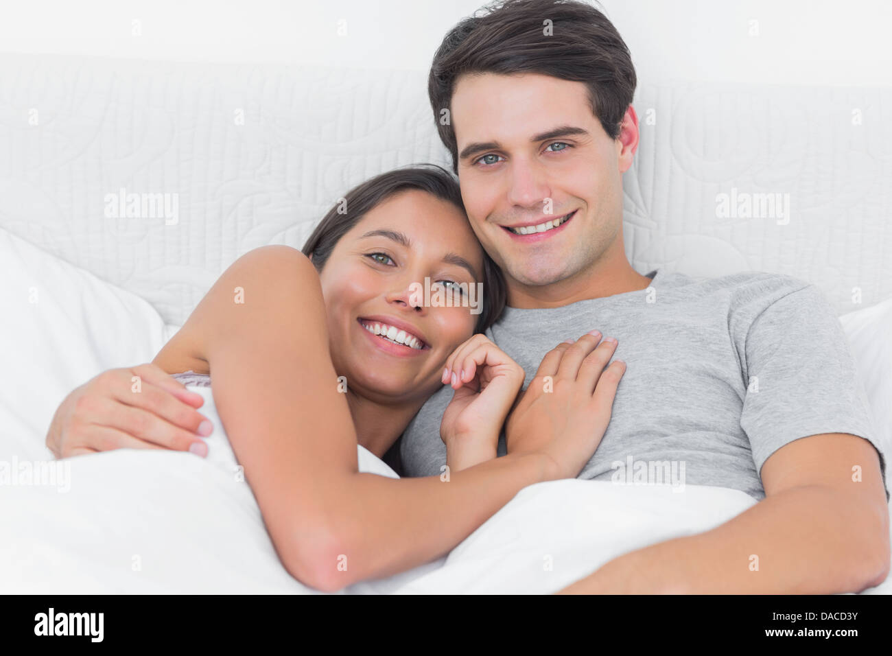 Woman embracing her boyfriend in bed Stock Photo - Alamy