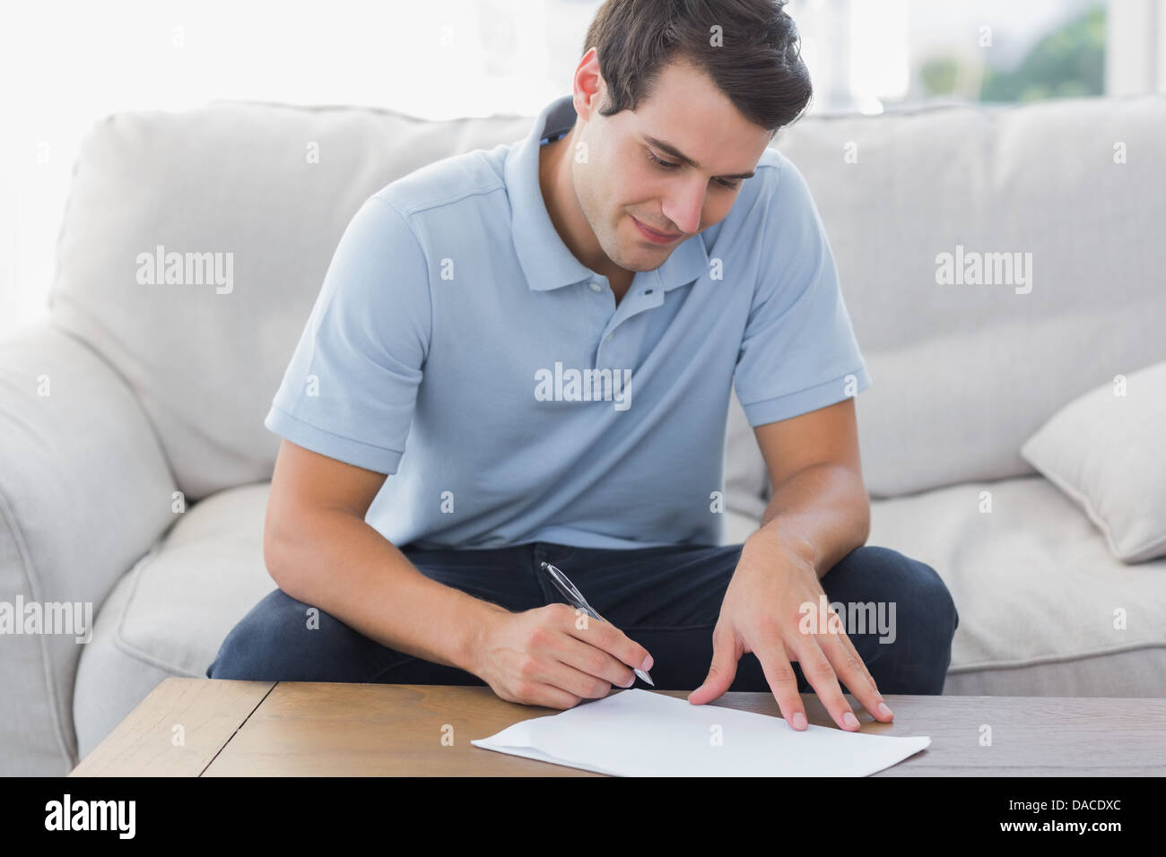 Handsome man writing on a paper Stock Photo - Alamy