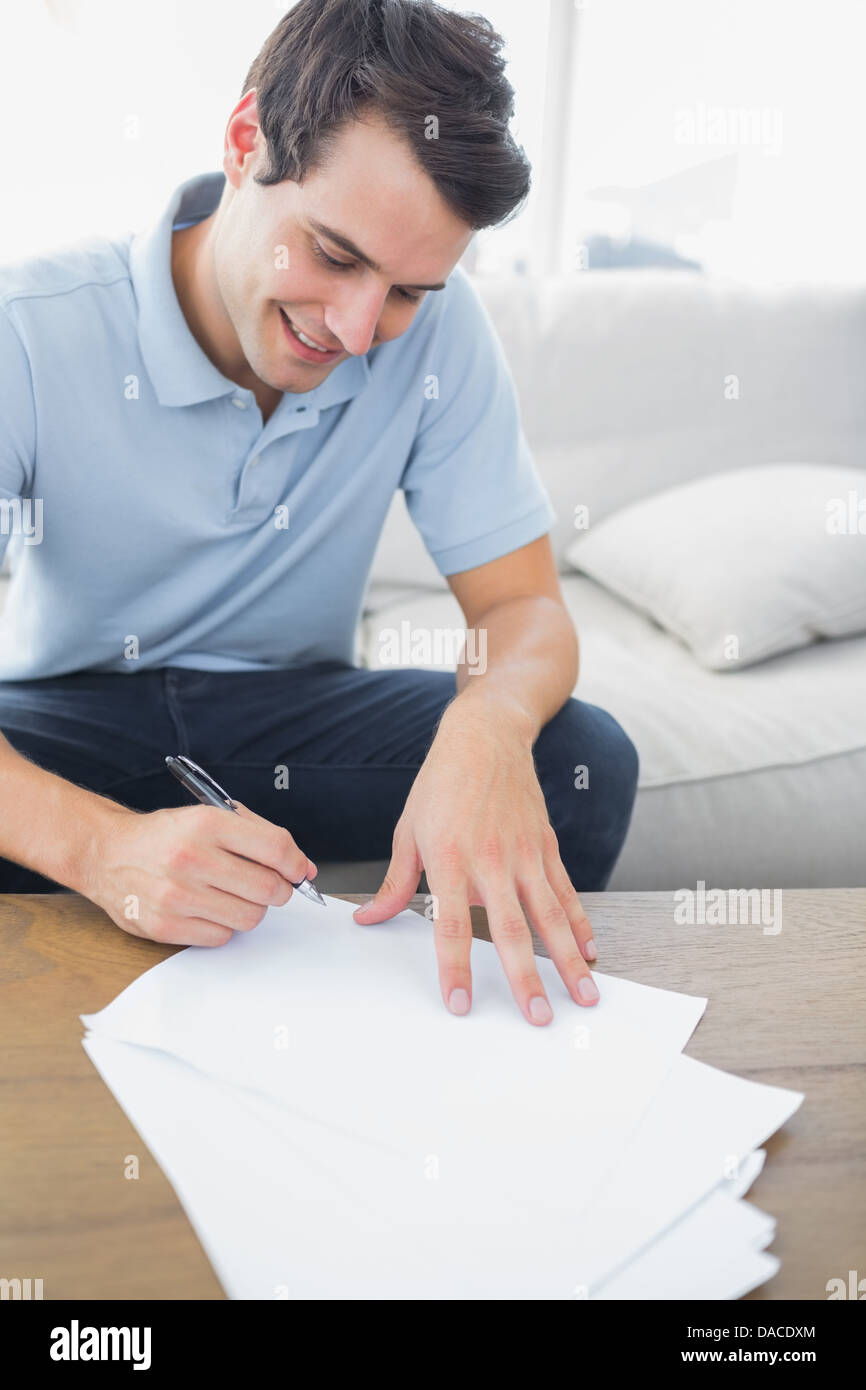 Cheerful man writing on a paper Stock Photo - Alamy