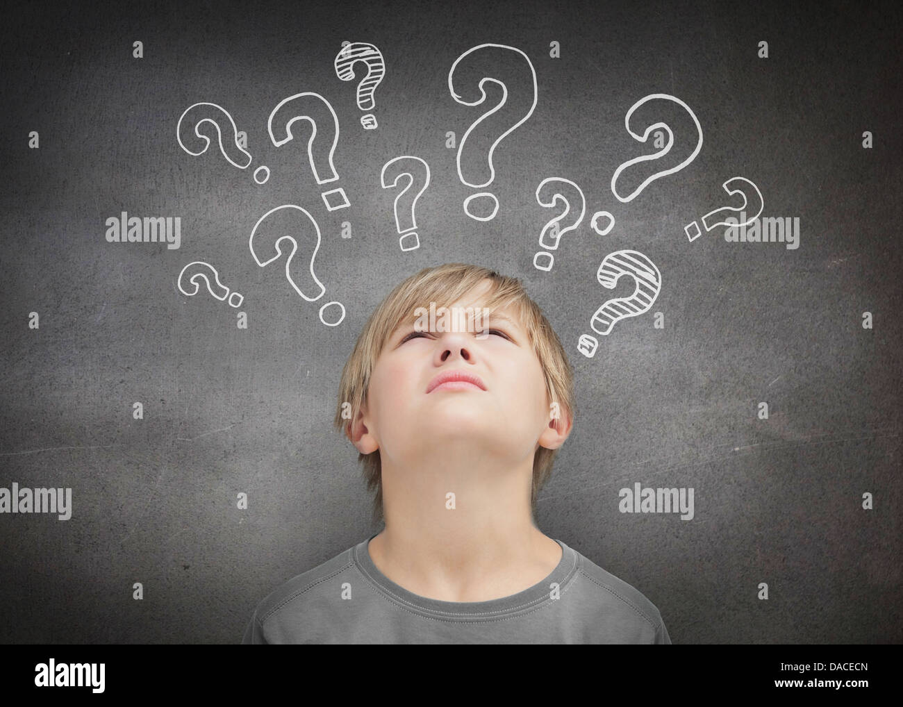 Thinking child looking at question marks Stock Photo - Alamy