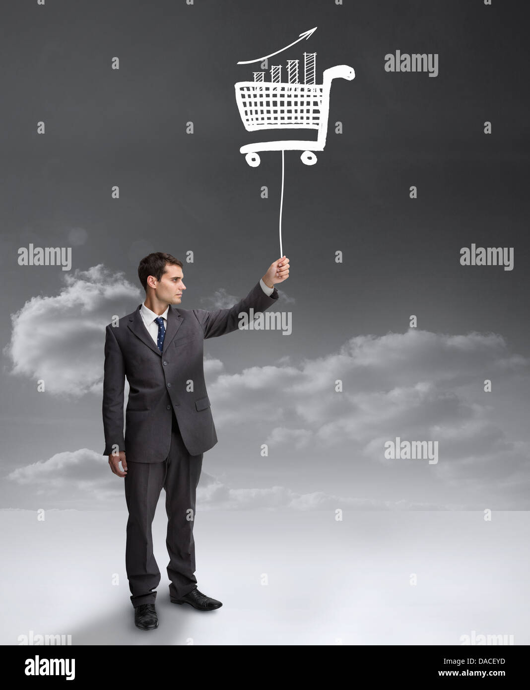 Businessman holding a floating shopping cart Stock Photo - Alamy