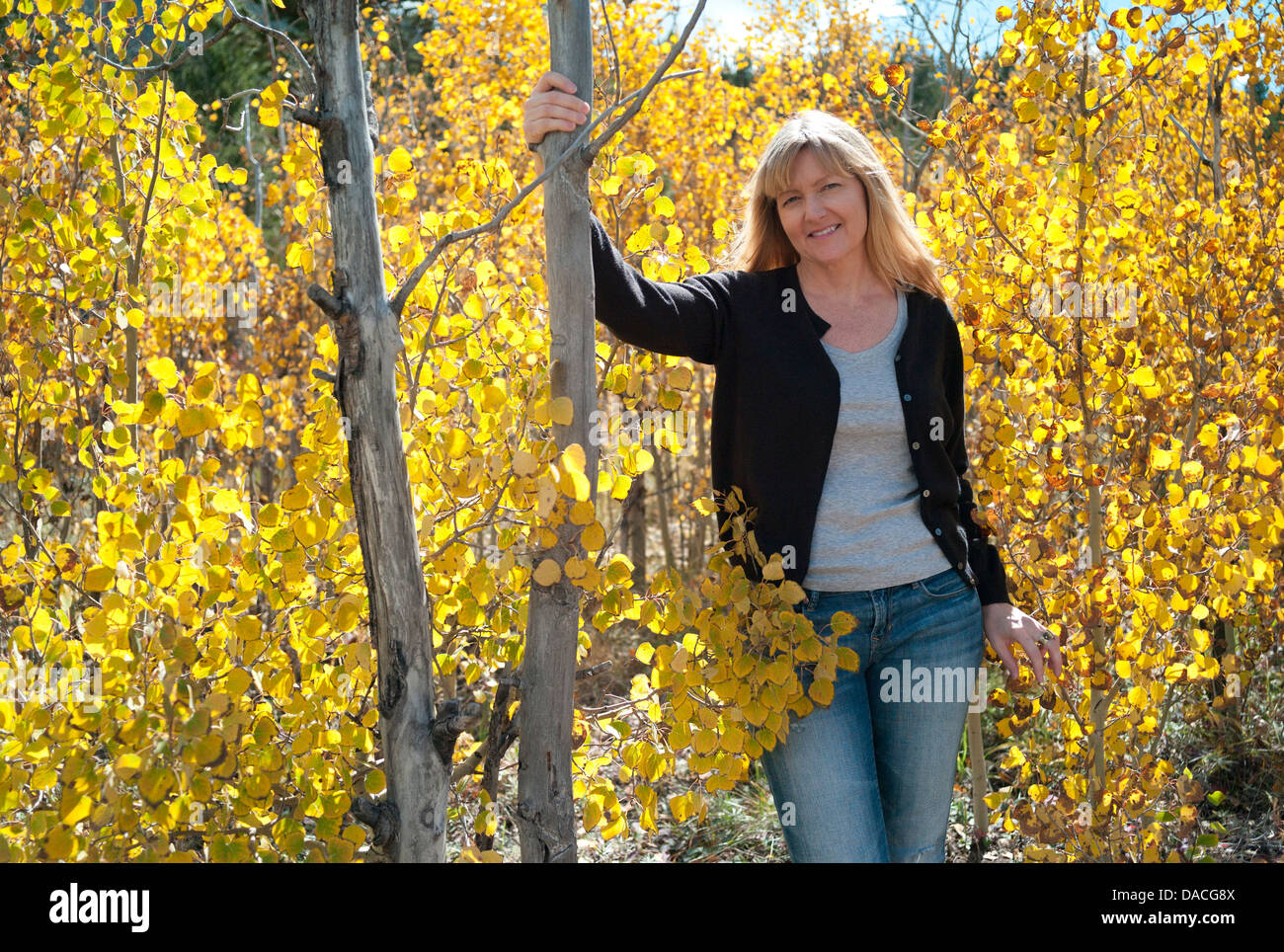 Woman standing among trees Stock Photo - Alamy